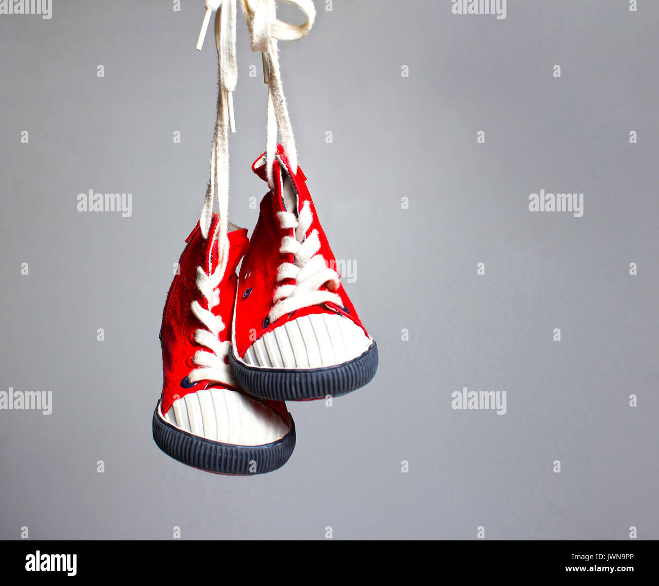 Sport baby shoes hanging on the rope Stock Photo - Alamy