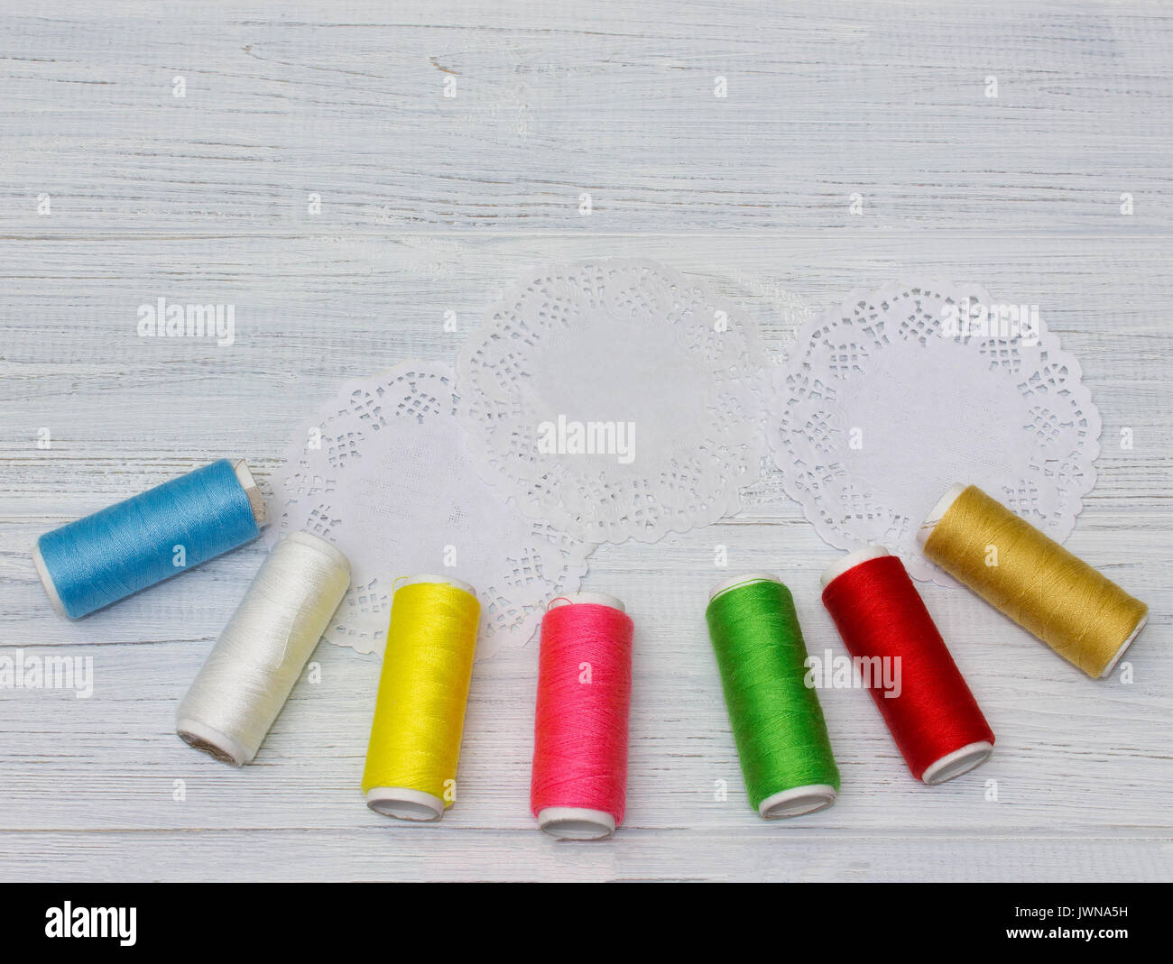Bobbins with colorful threads on old wooden table background Stock ...