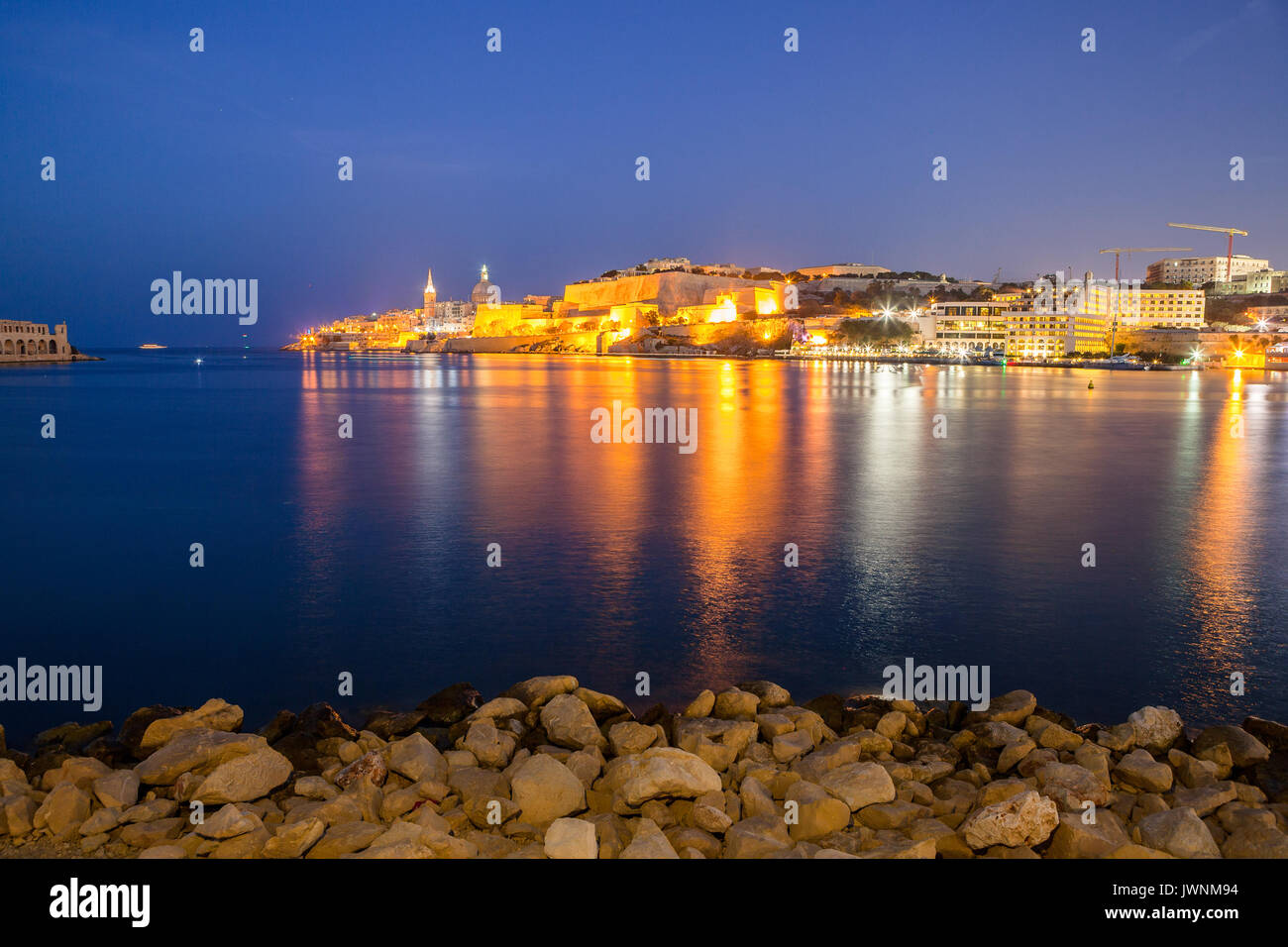 Summer night view of Valetta profile over sea with rocky shore at the ...