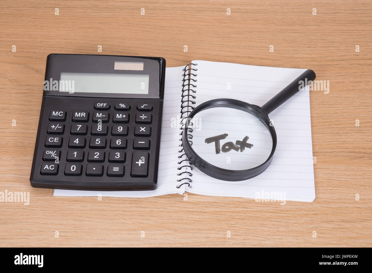 Payment and calculation of Tax concept with a calculator and magnifying ...