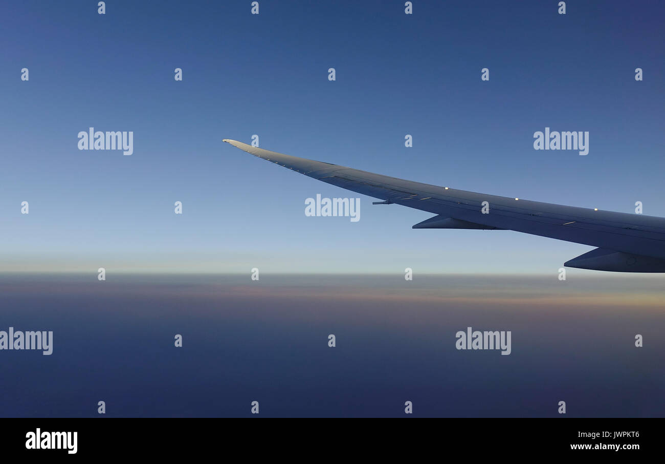 Looking through window aircraft during flight. Flying over the blue sky ...