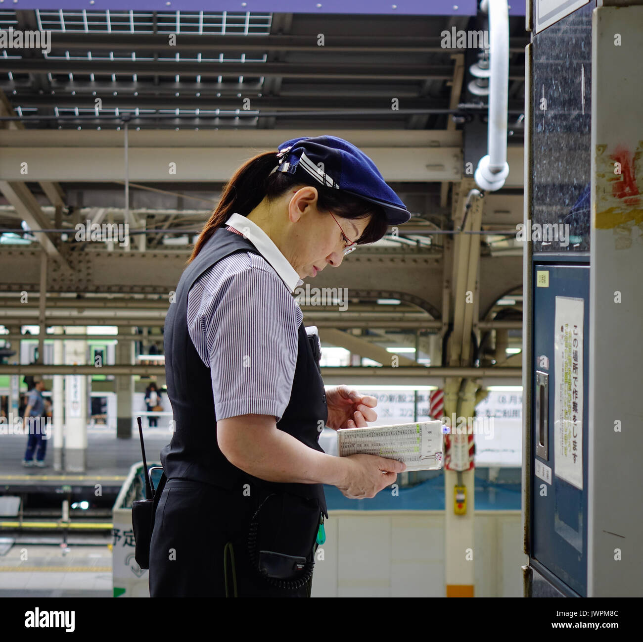 Tokyo, Japan - May 15, 2017. A female staff working at railway station ...