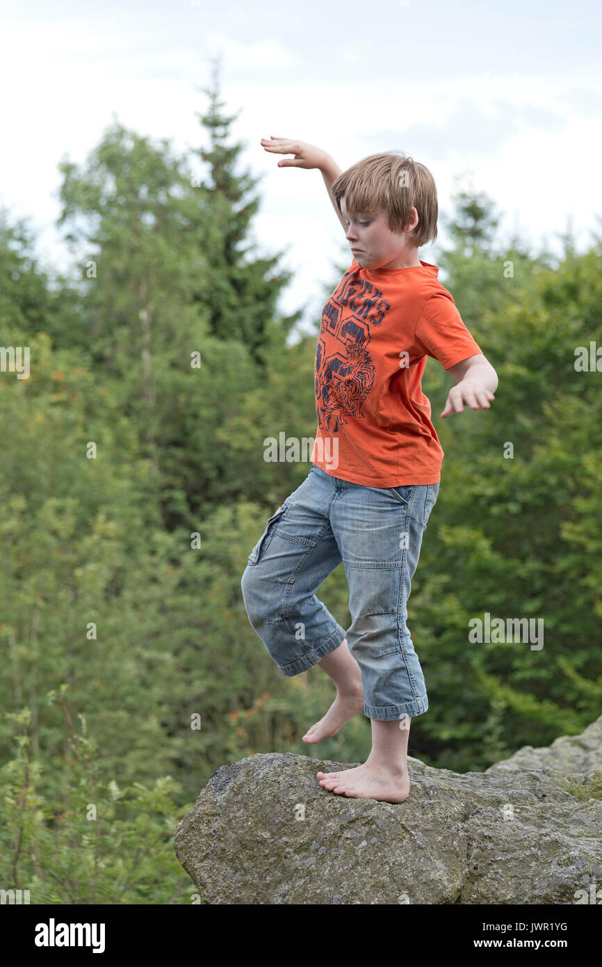 boy standing on rocks Stock Photo - Alamy