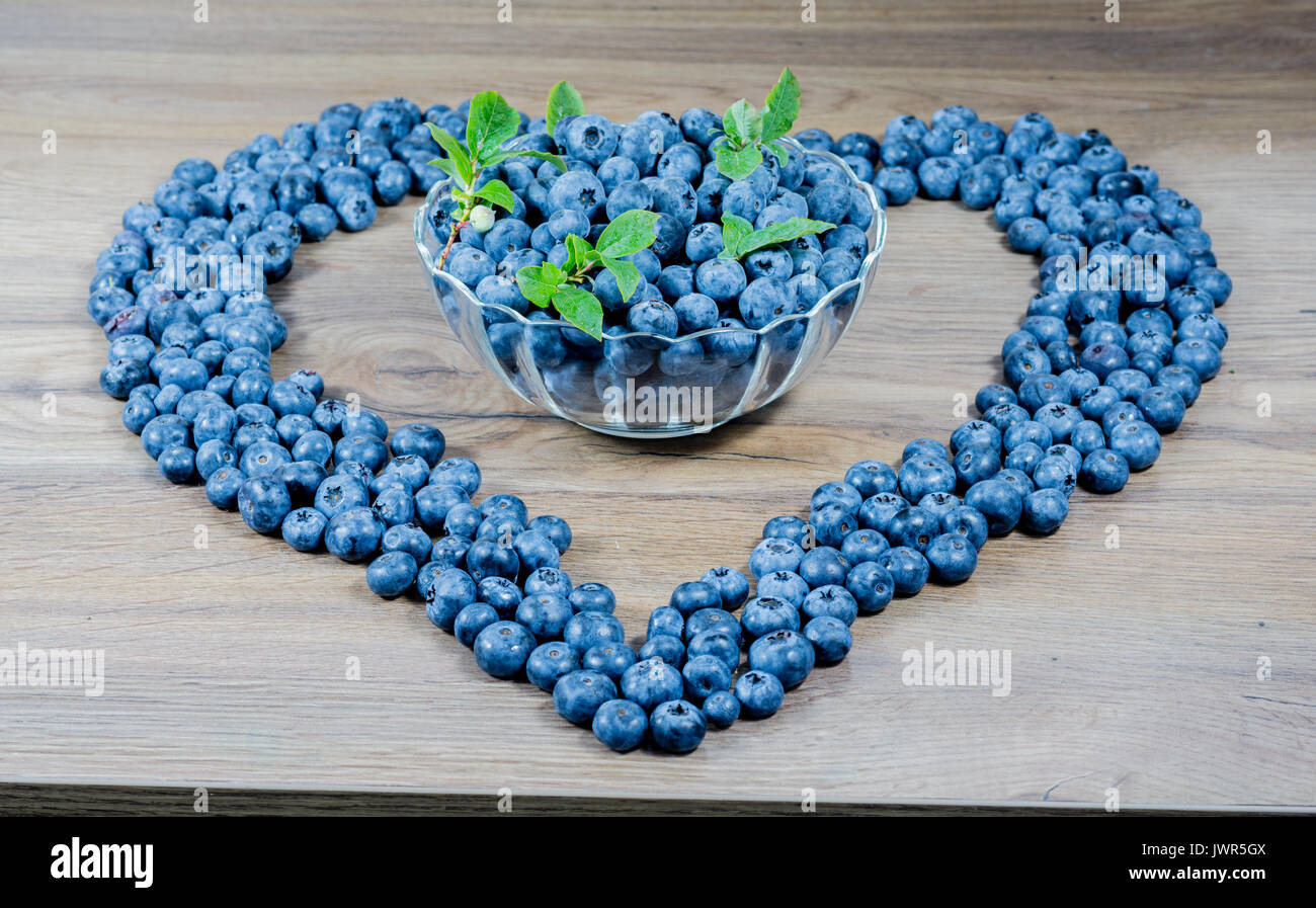 Tasty fresh blueberries heathberry hearth shape on rustic wood table ...