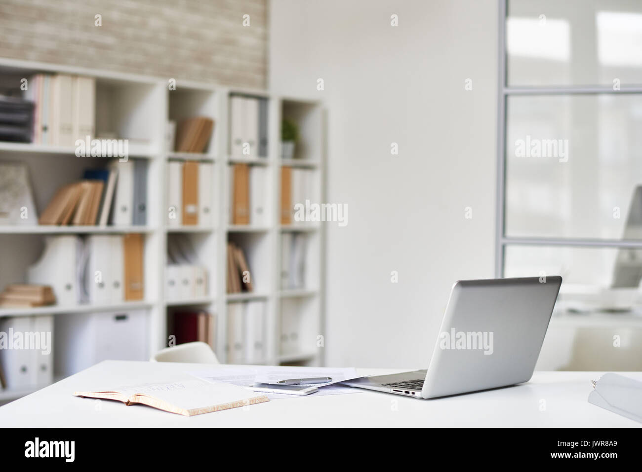 Background image of empty workplace with laptop on desk in modern light ...