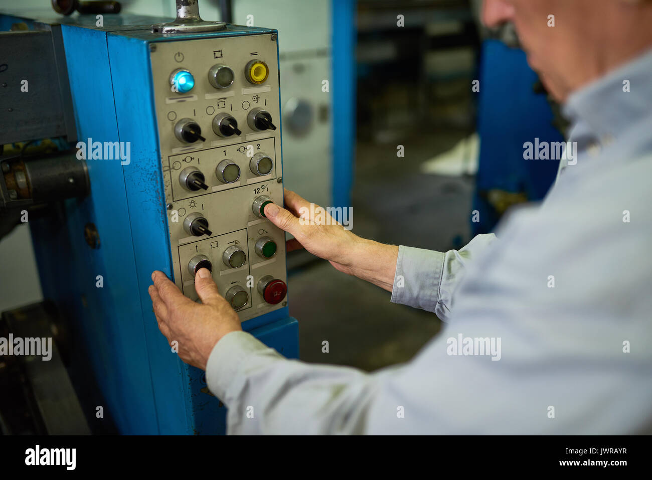 Closeup of unrecognizable senior man operating machines in factory ...