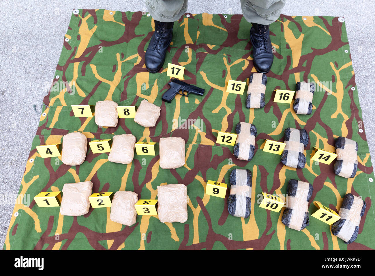 Policeman guarding seized drug packages Stock Photo - Alamy