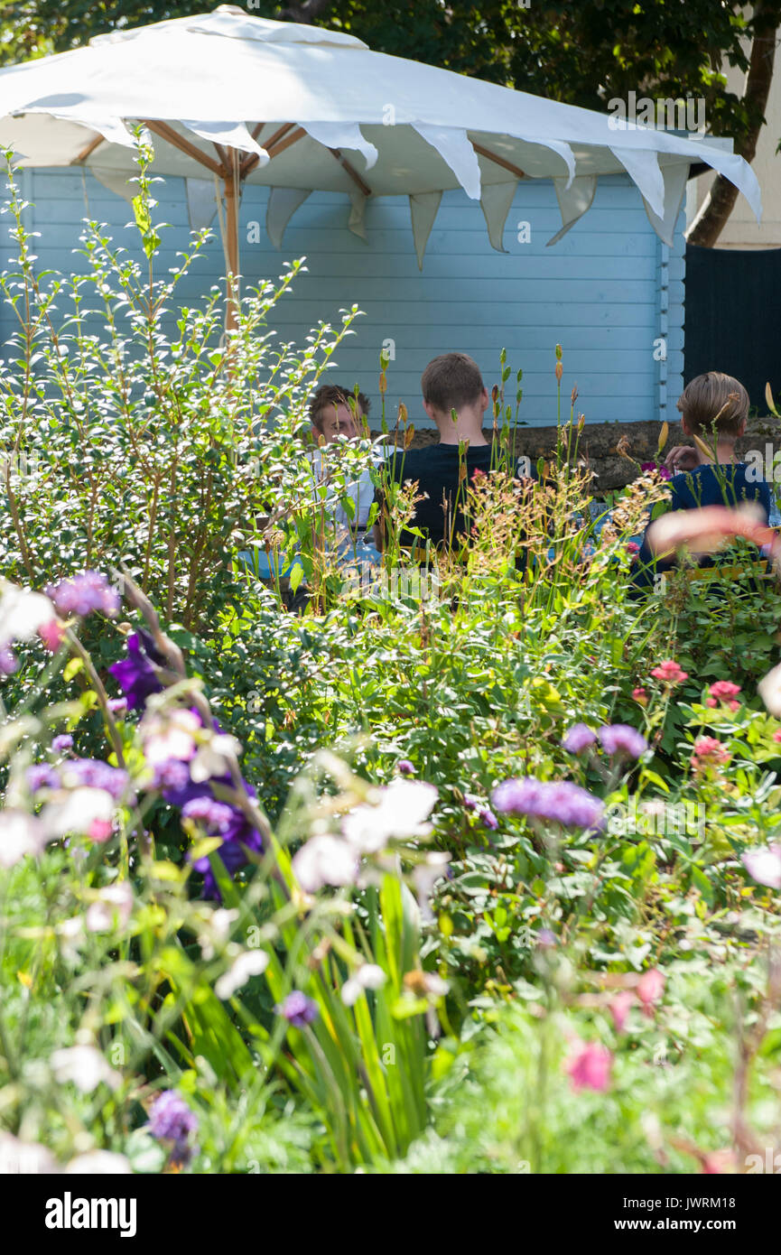 Some friends enjoy their lunch outside in an English country garden ...