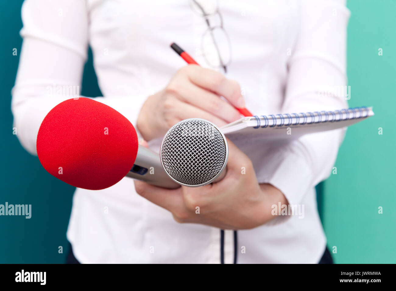 Female reporter taking notes at news conference Stock Photo - Alamy