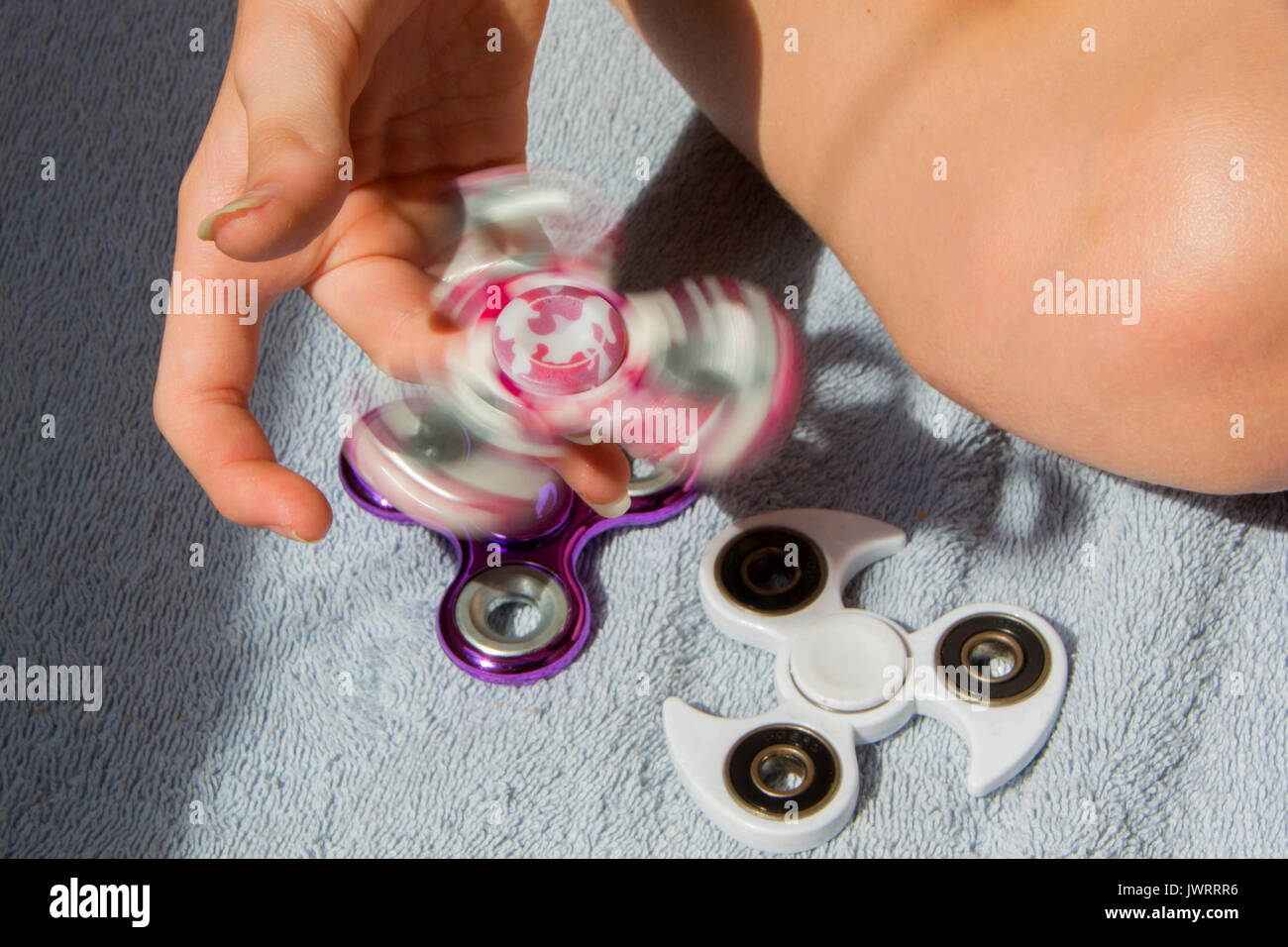 A girl is holding a popular toy fidget spinner. Girl playing with a ...