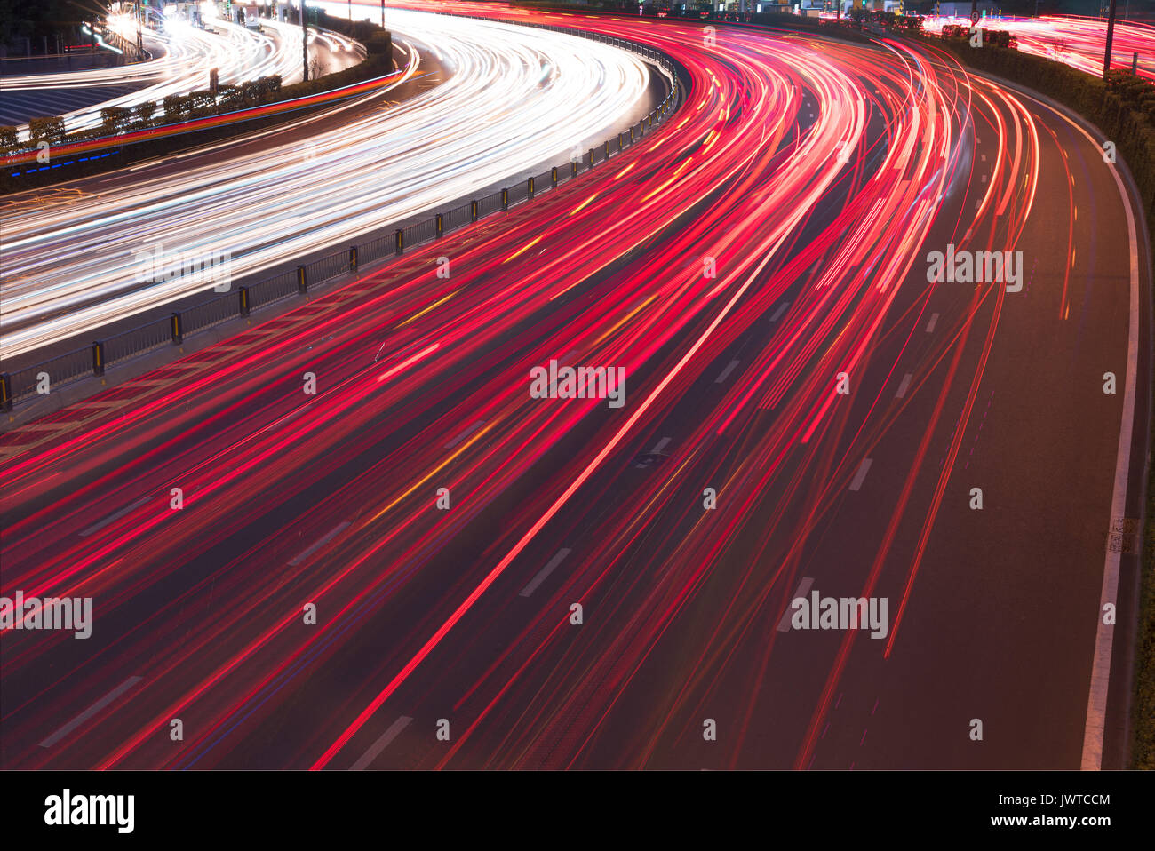 Cars light trails on a curved highway road at night in Chengdu city ...