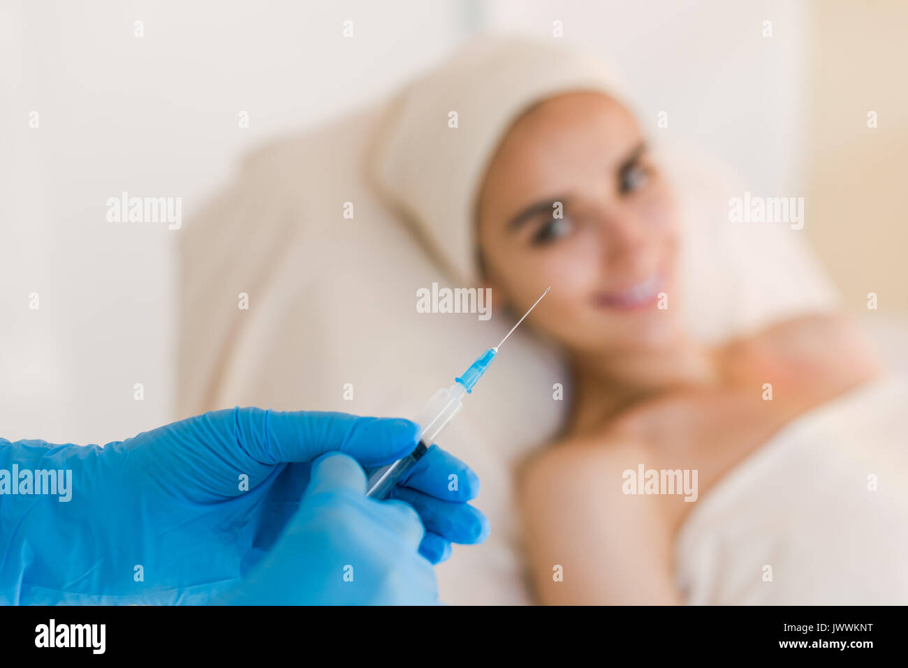 Close up view of doctor in sterile gloves making Botox facial injection ...