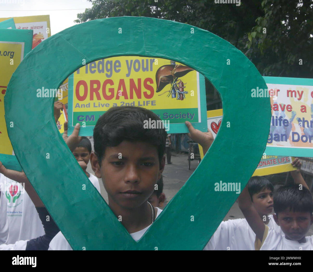 Children hold the poster during the "Organ Donation Day" awareness ...