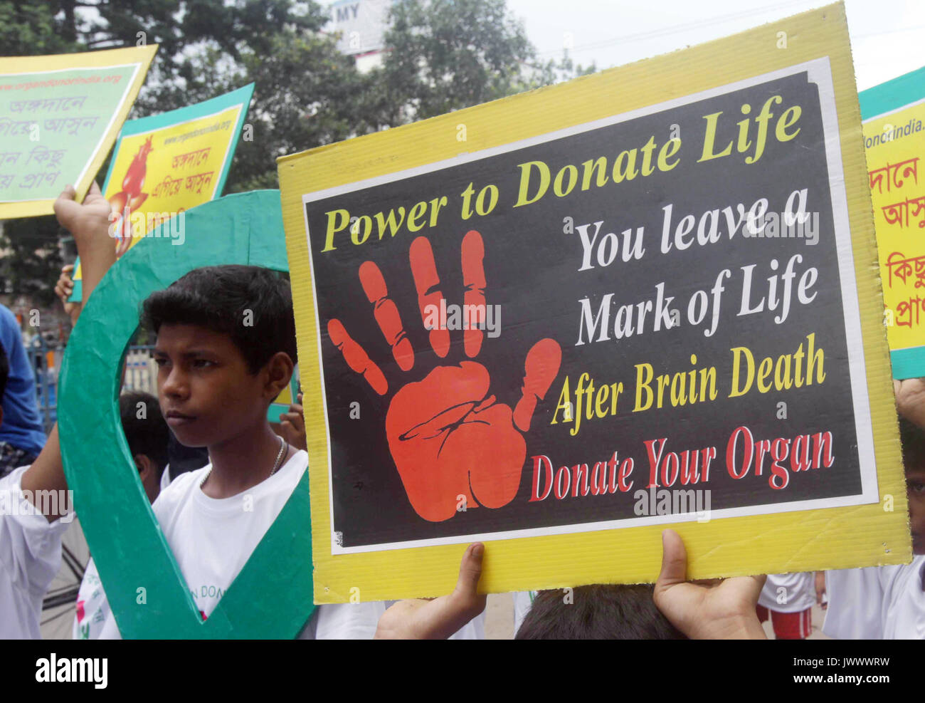 Children hold the poster during the "Organ Donation Day" awareness ...