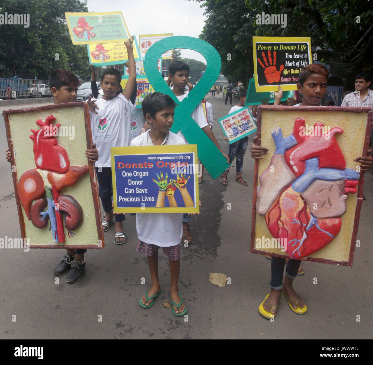 Children hold the poster during the "Organ Donation Day" awareness ...