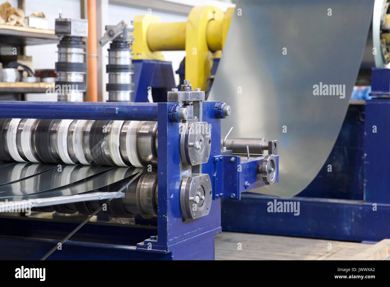 Process of cutting a wide sheet of metal into narrow strips on a ...