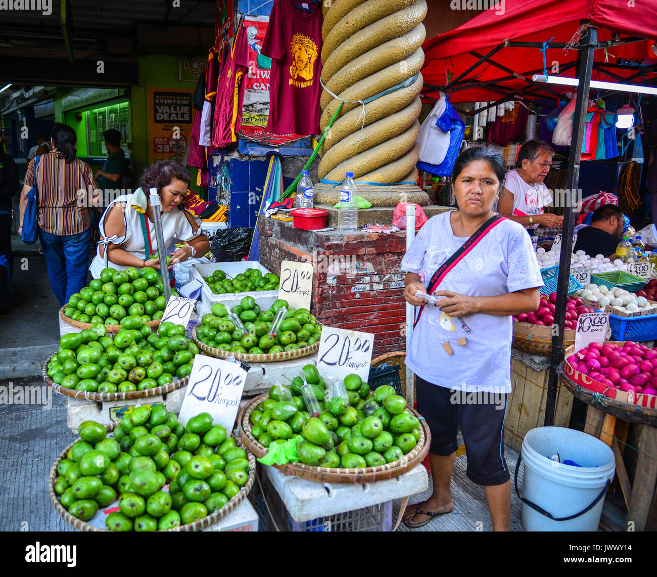 Manila, Philippines - Apr 12, 2017. A woman selling green mangoes at ...