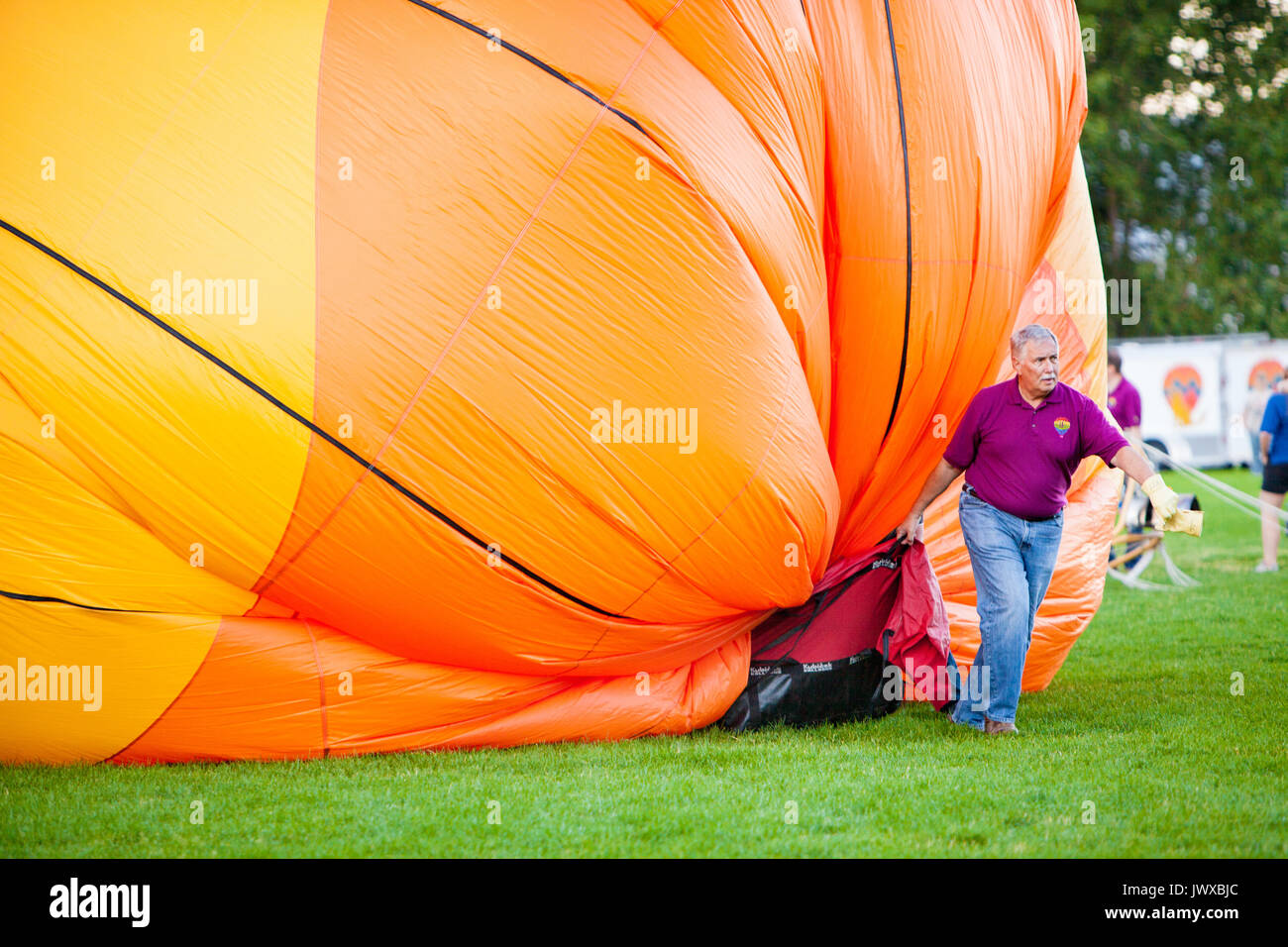 A man unfolding a hot air balloon preparing it for a flight at the ...