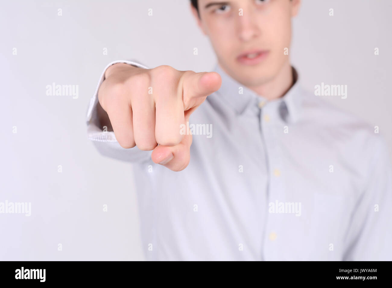 Close up of a young man pointing camera. Isolated white background ...