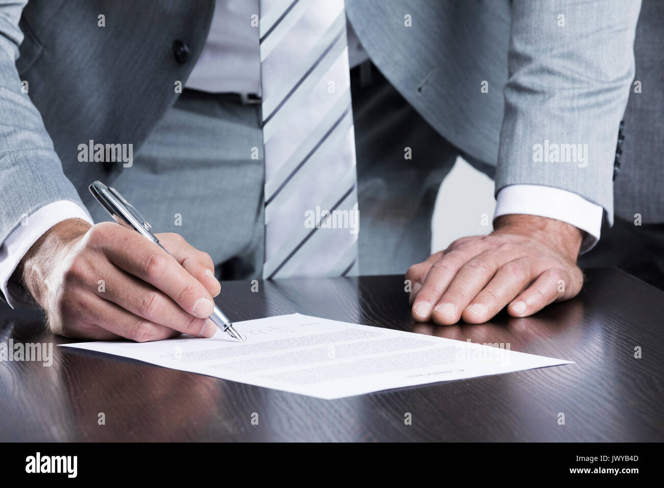 Business man sign contract standing near the table Stock Photo - Alamy