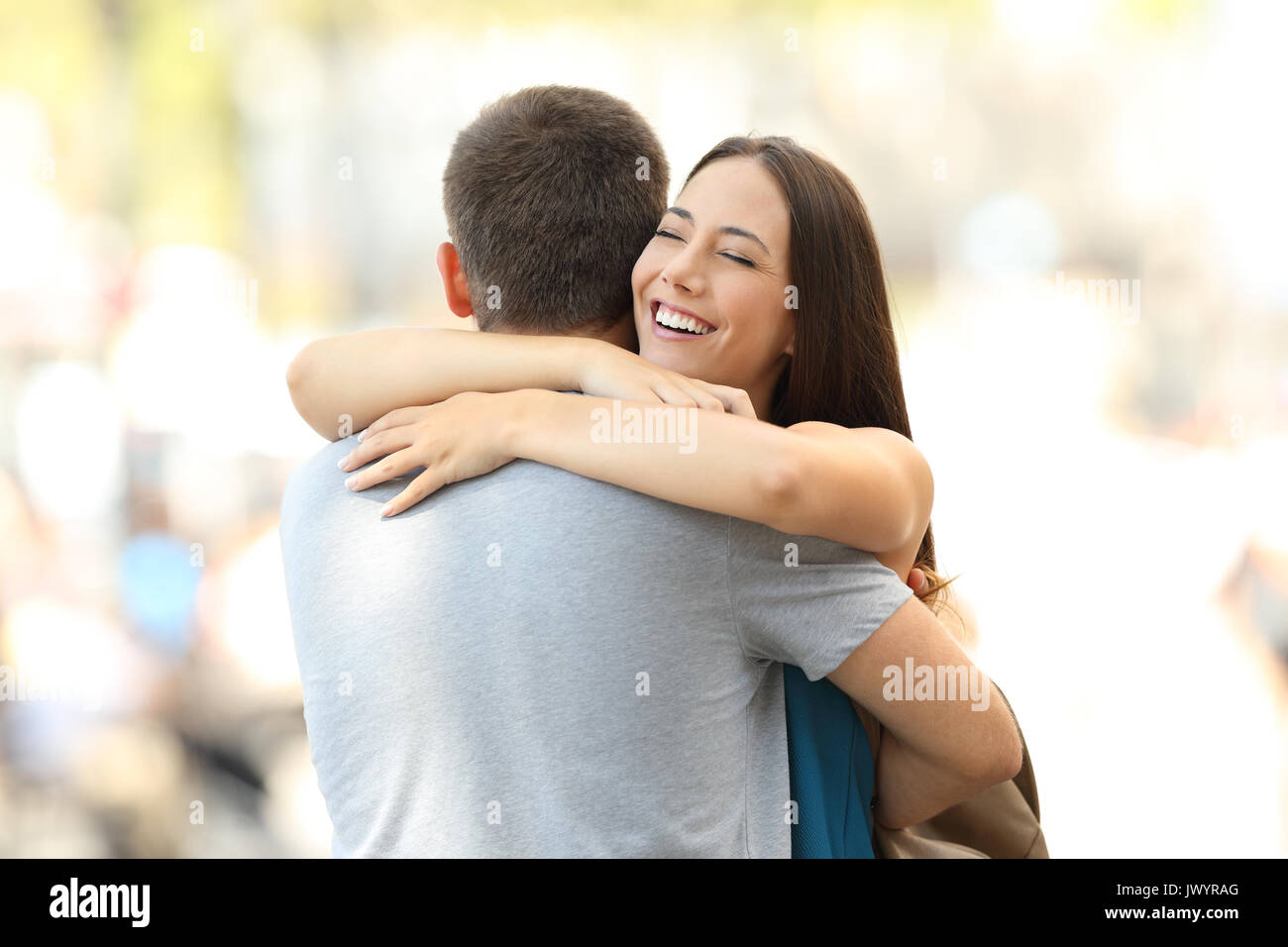 Happy girlfriend hugging her partner after encounter on the street ...