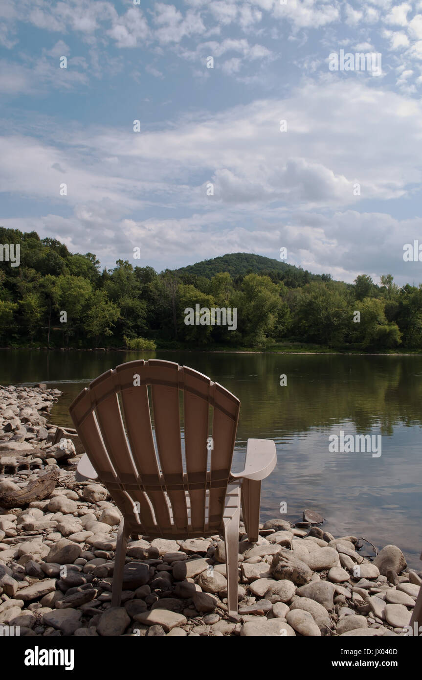A chair on the river bank under bright sunny skies Stock Photo - Alamy