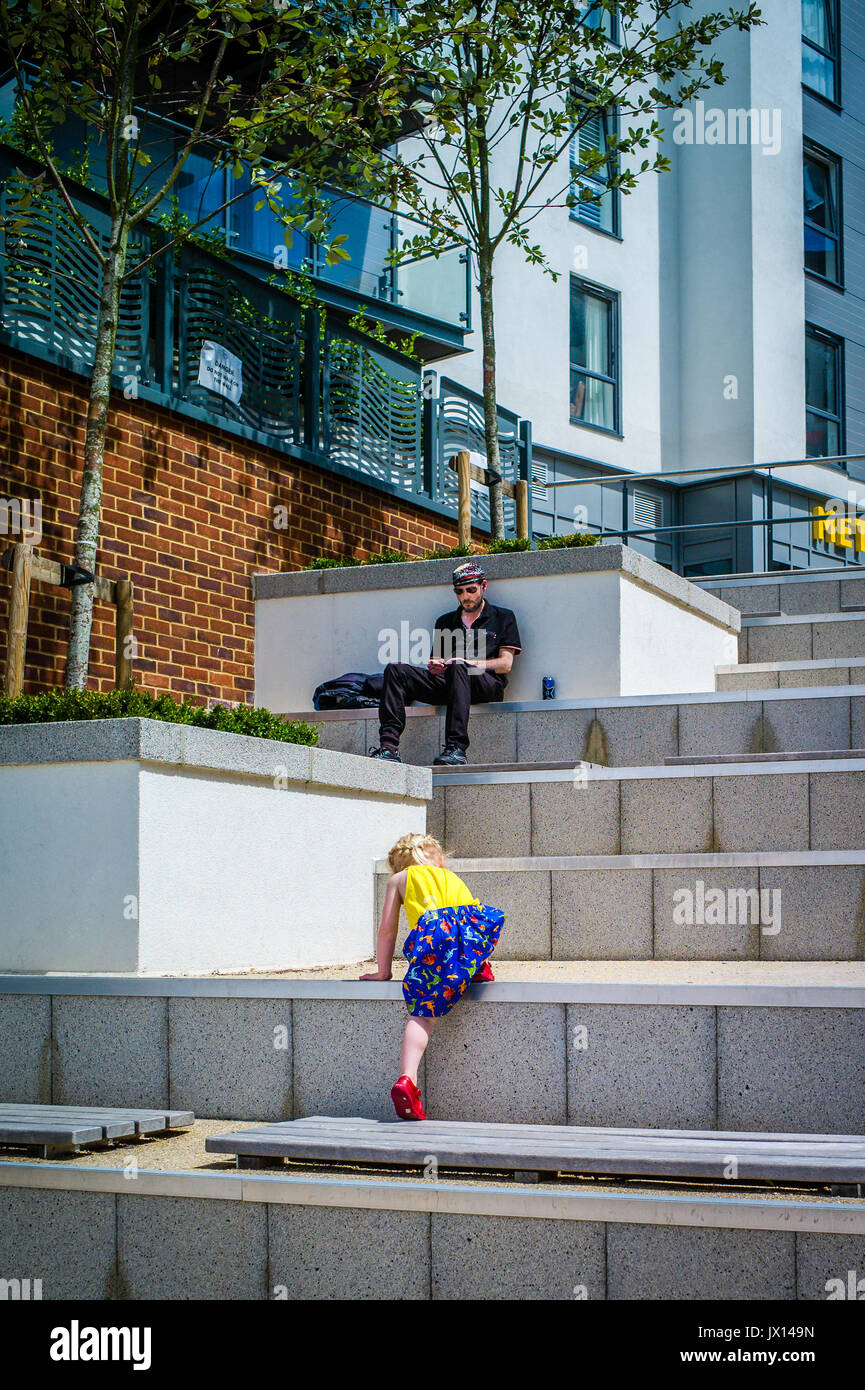 A small girl struggles to climb a flight of very large stone steps at a ...