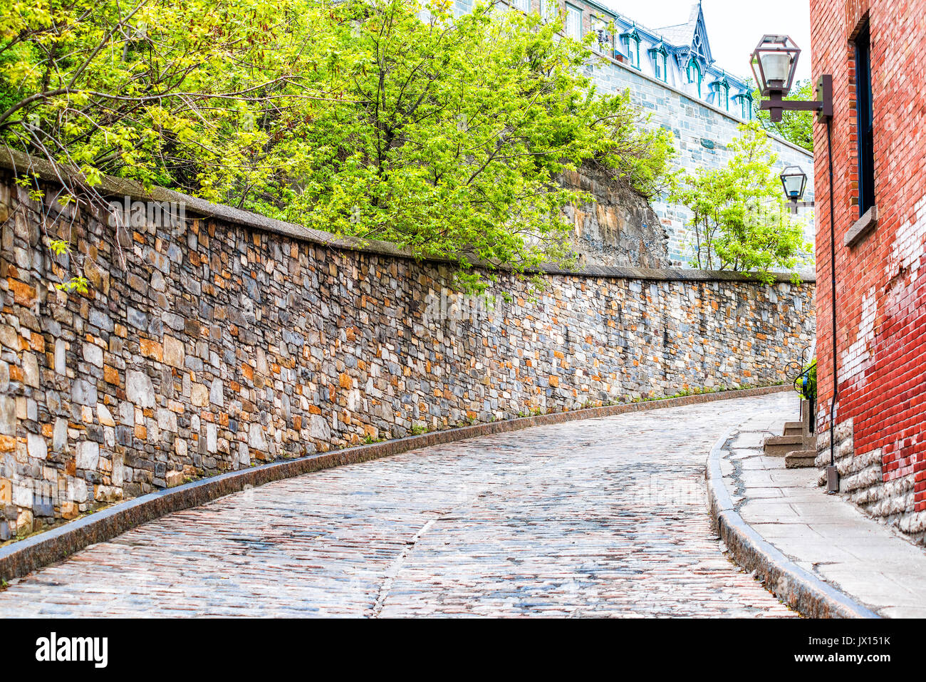 Lower old town narrow street with cobblestone road on incline uphill ...