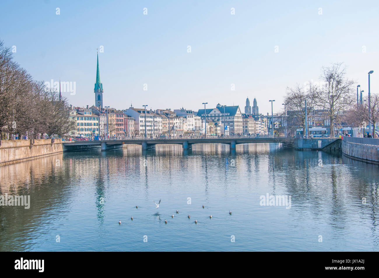 Zurich Switzerland reflected in the water on a day with a blue sky ...