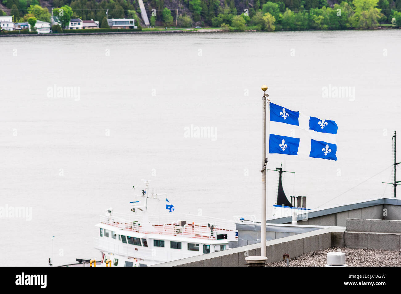 Blue Quebec flag on rooftop with view of boat ship on Saint Lawrence ...