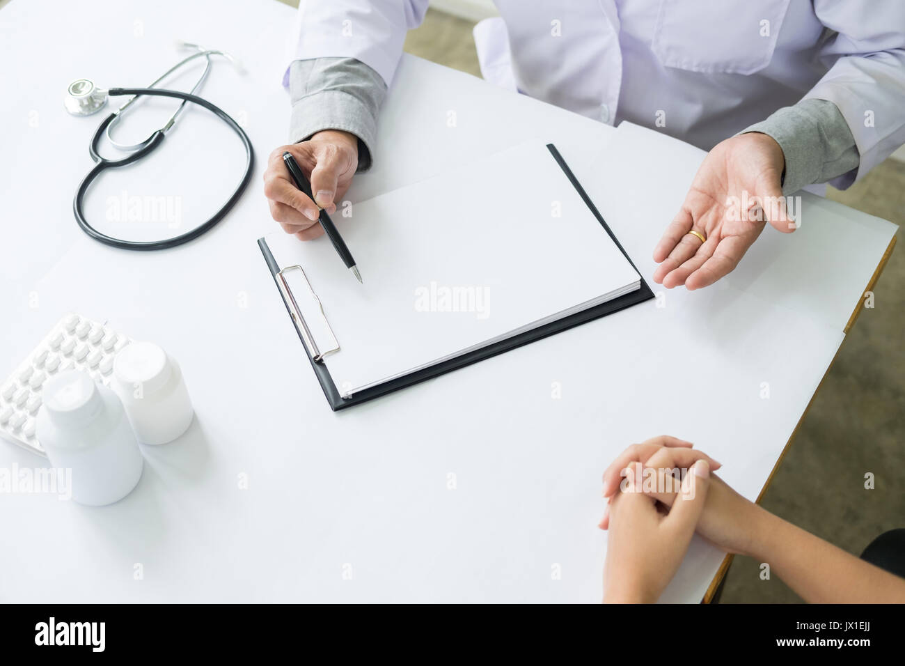 patient listening intently to a male doctor explaining patient symptoms ...