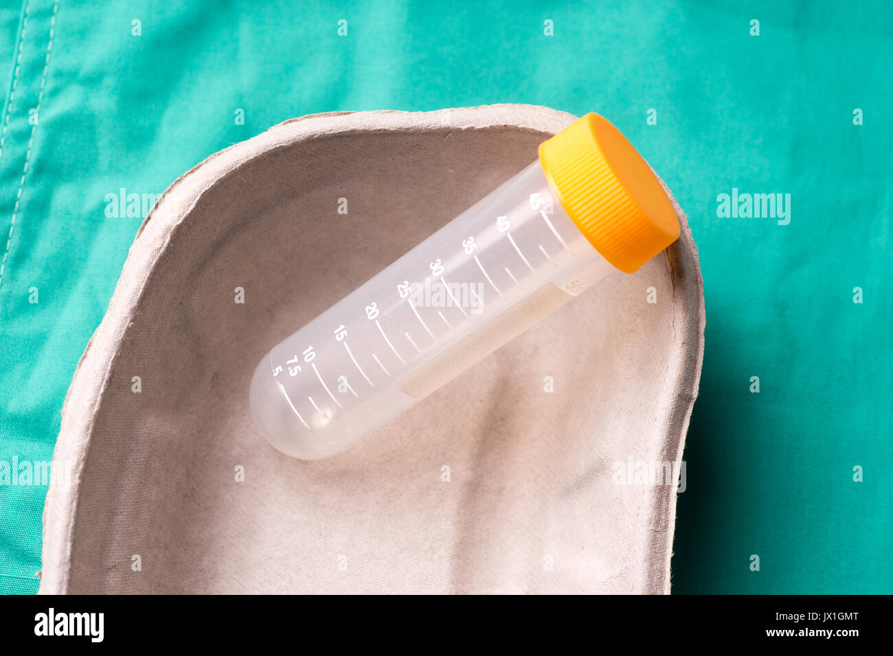 Medical test tube lying in a one use capsule on the hospital's green ...