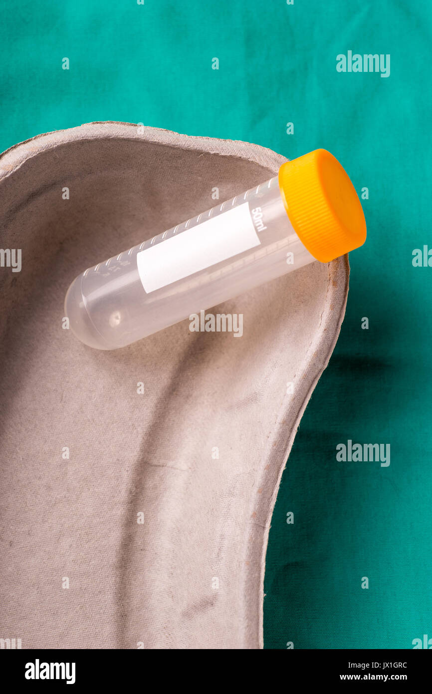 Medical test tube lying in a one use capsule on the hospital's green ...