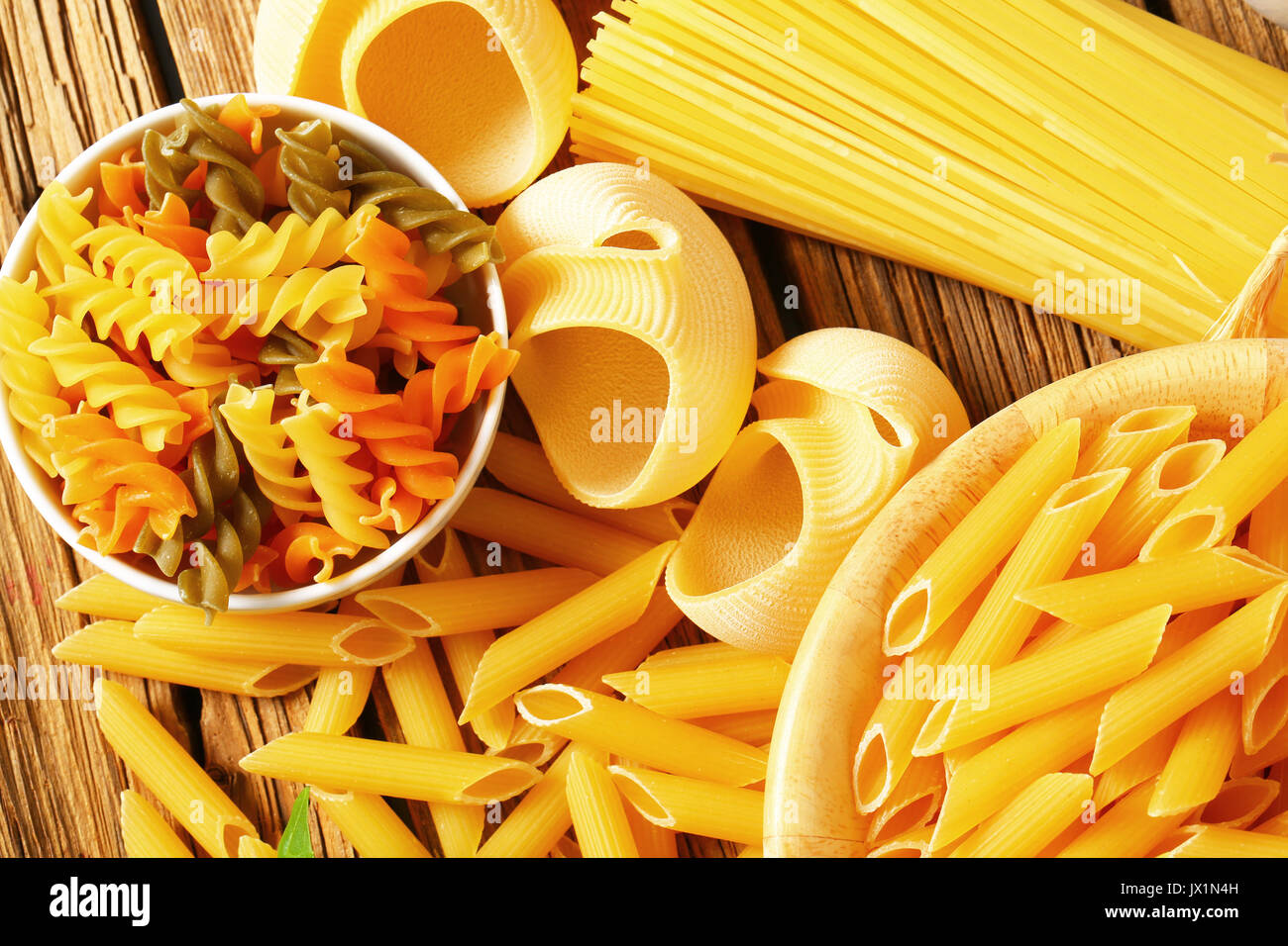 Various types of dried pasta on wooden background Stock Photo - Alamy