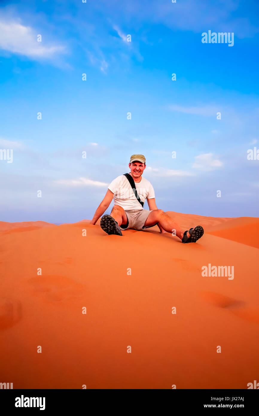 Tourist resting on top of the stunning sand dunes of Sahara desert in ...