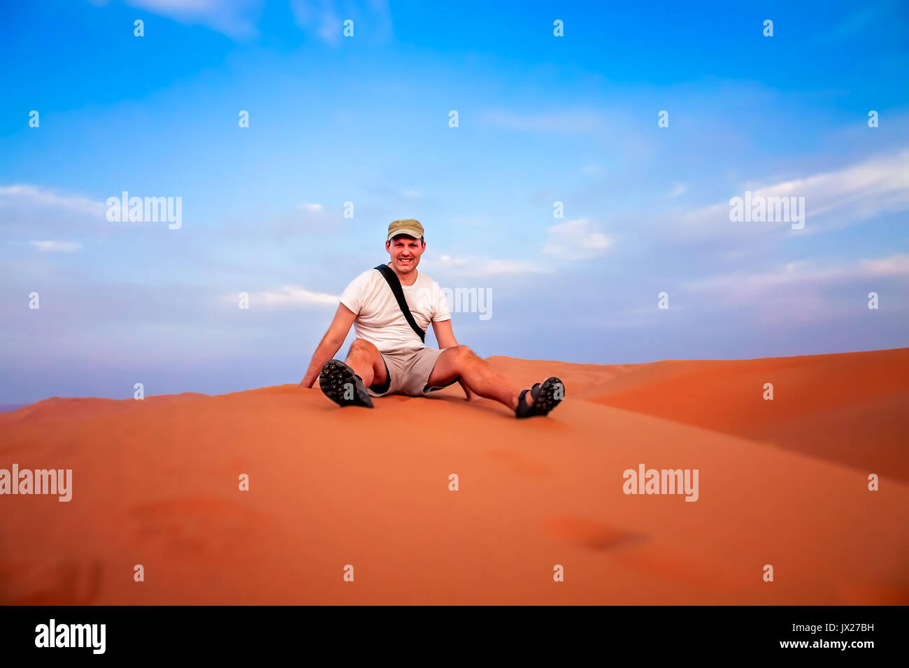 Tourist resting on top of the stunning sand dunes of Sahara desert in ...