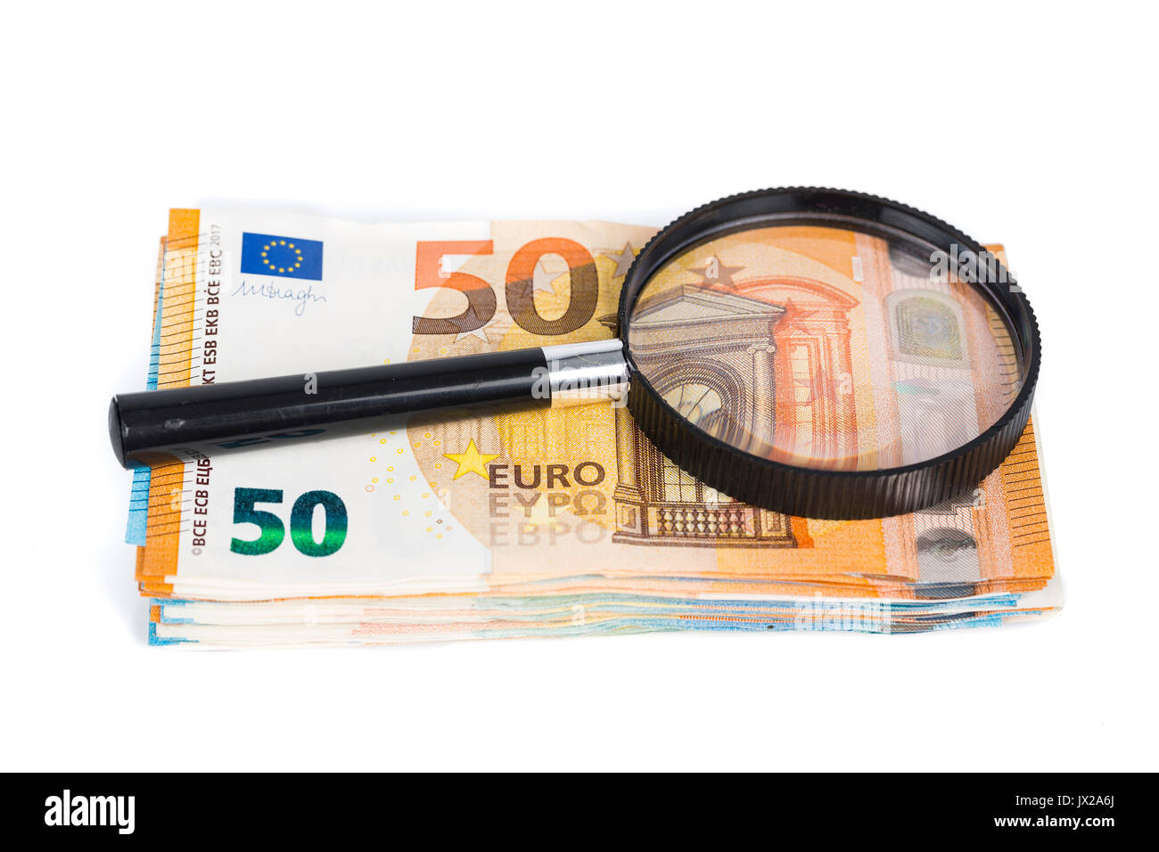 magnifying glass and pile of euro notes on white background. Top view ...