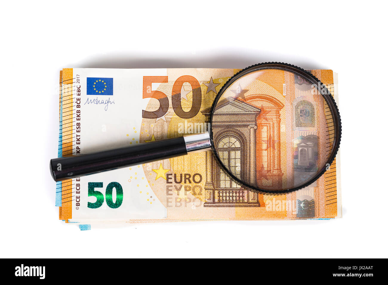 magnifying glass and pile of euro notes on white background. Top view ...