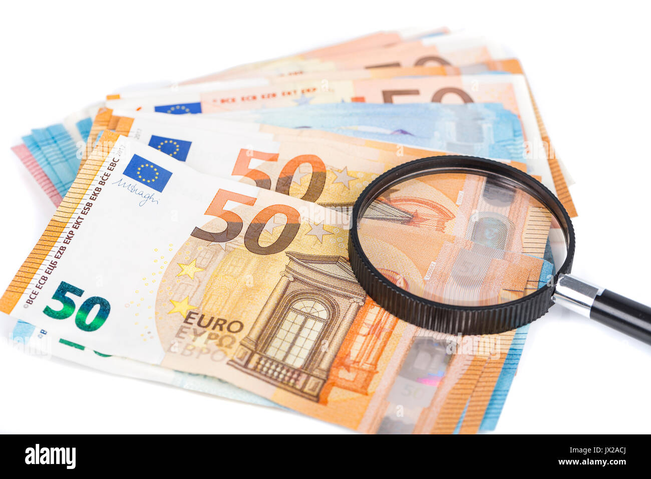 magnifying glass and pile of euro notes on white background Stock Photo ...