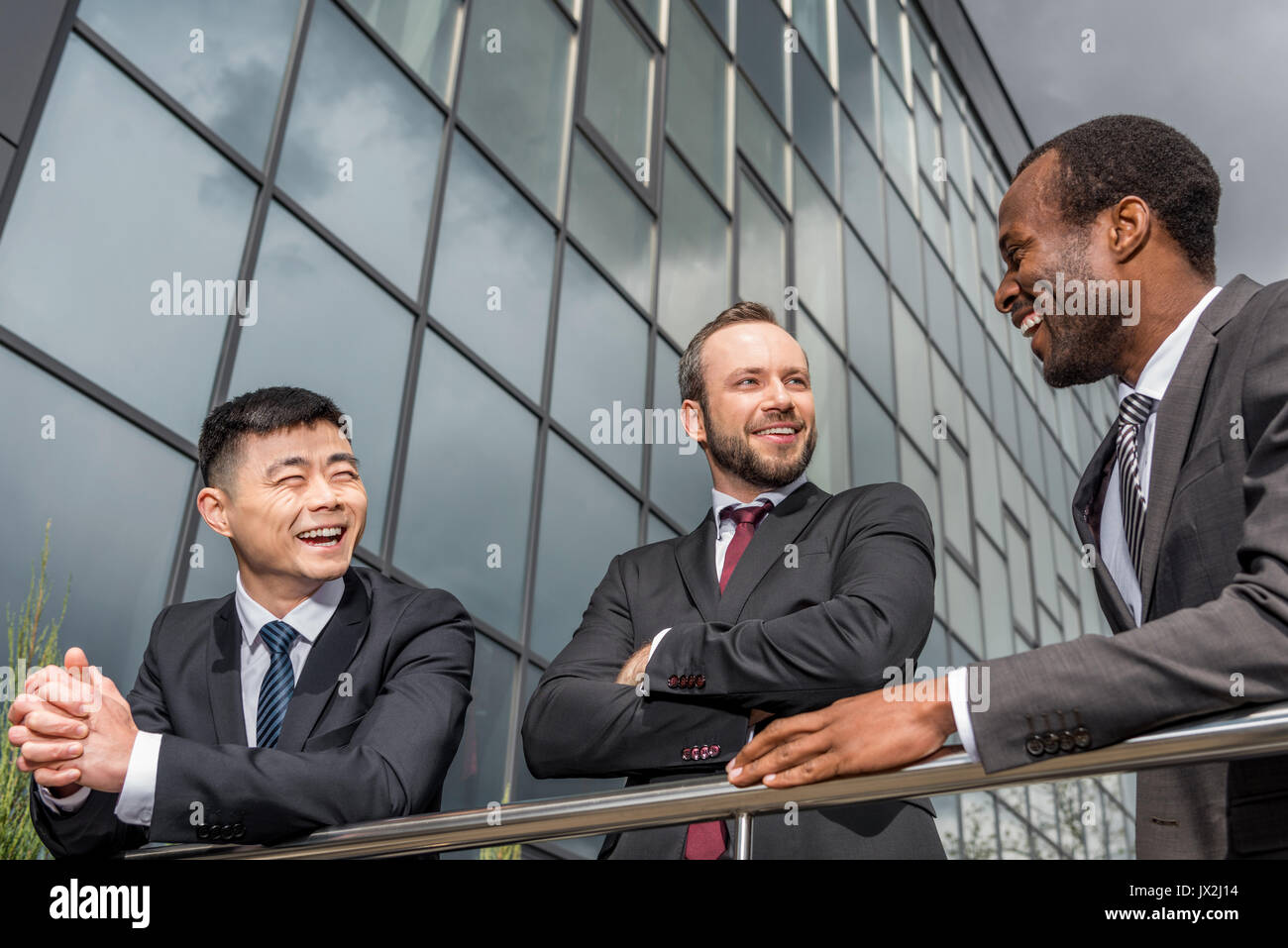 multicultural business team meeting outdoors near office building ...
