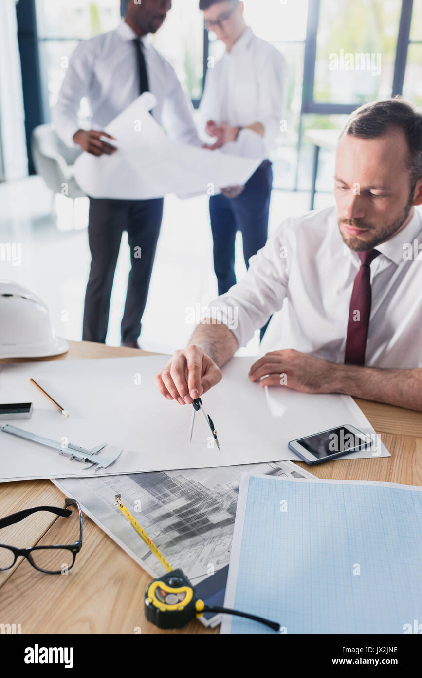 architect working on new project with colleagues behind in modern ...
