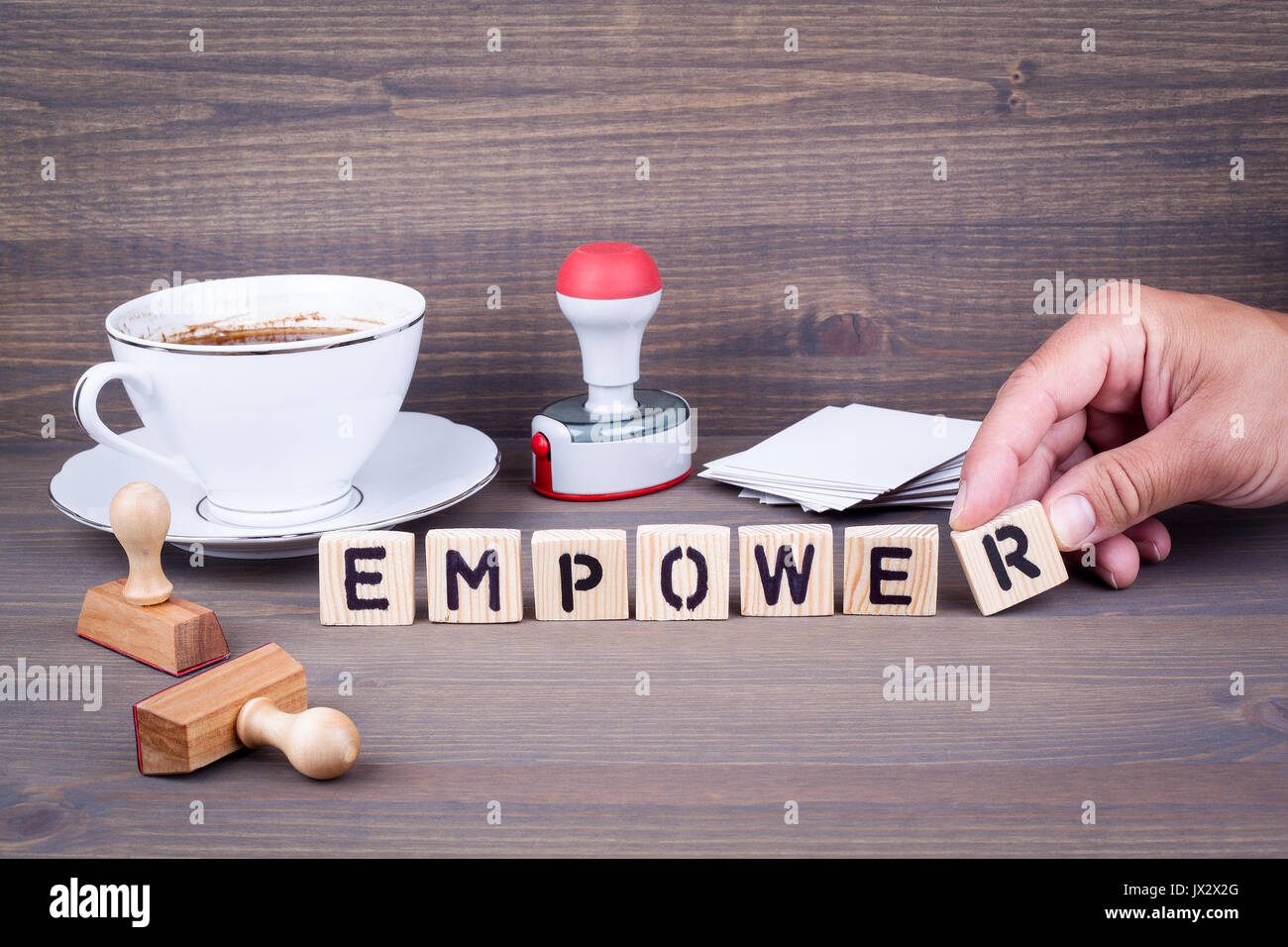 empower. Wooden letters on dark background. Office desk Stock Photo - Alamy