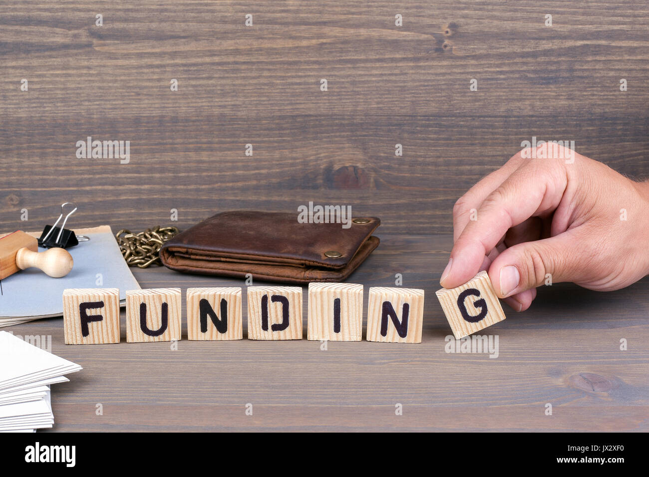 Funding concept.Wooden letters on dark background. Office desk Stock ...