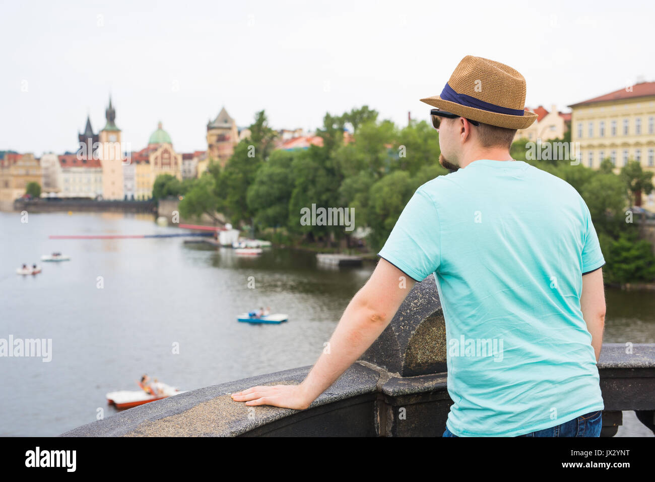 Back view of happy stylish tourist on Charles Bridge, Prague, Czech Republic. Handsome man ...