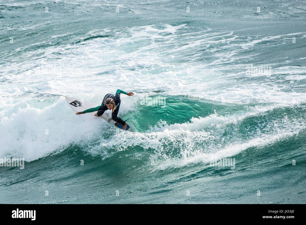 Surfing UK. A female surfer riding a wave at Fistral in Newquay ...
