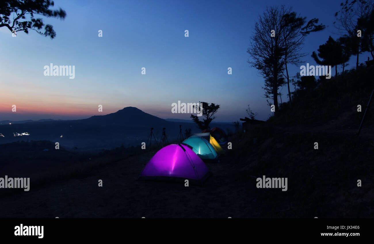 camping tents at twilight time with mountain background Stock Photo - Alamy