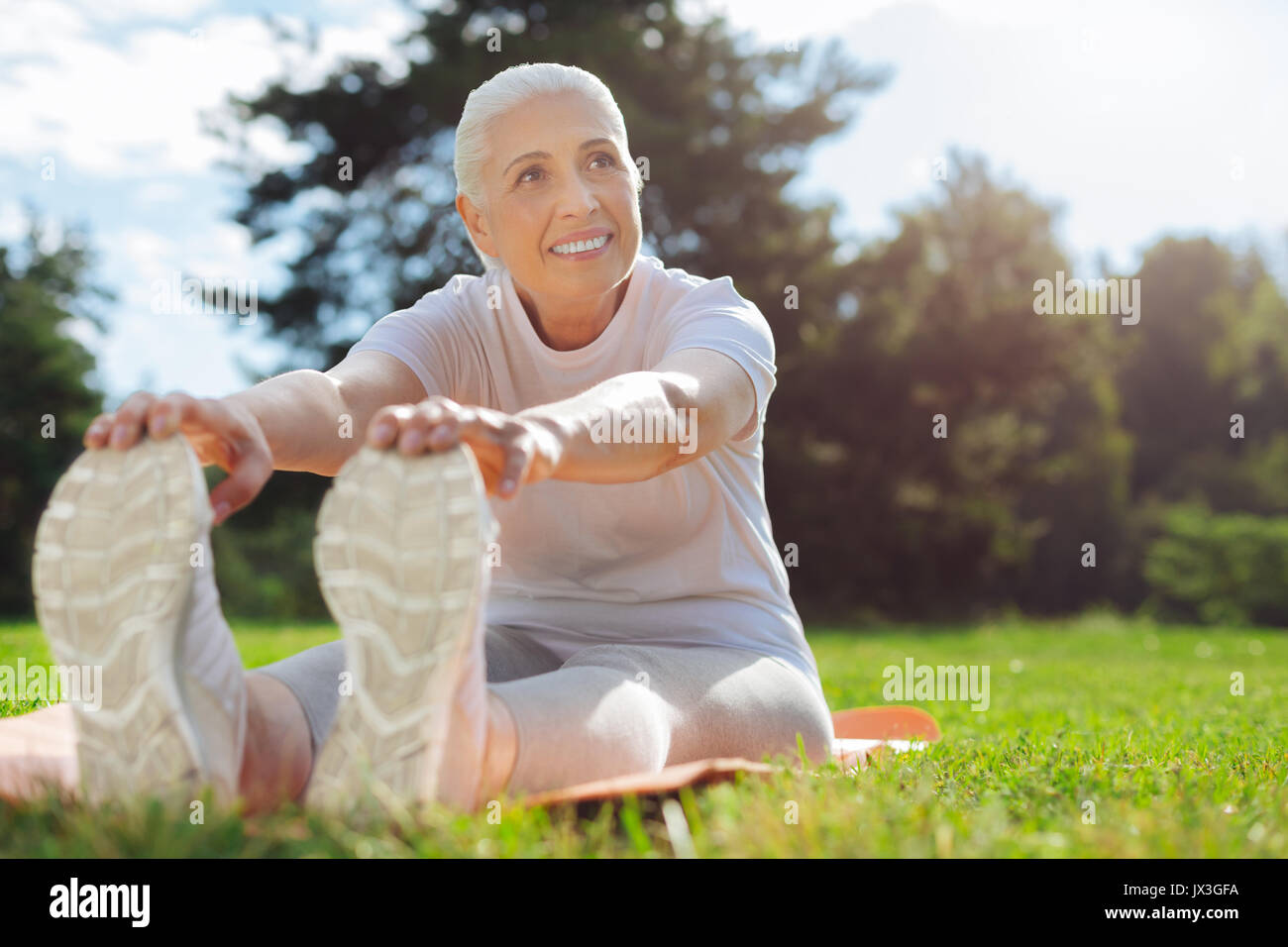 Joyful mature woman stretching her back Stock Photo - Alamy
