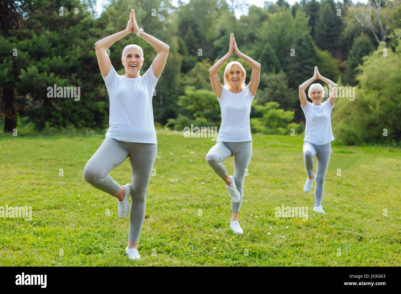 Three women standing on one leg Stock Photo - Alamy