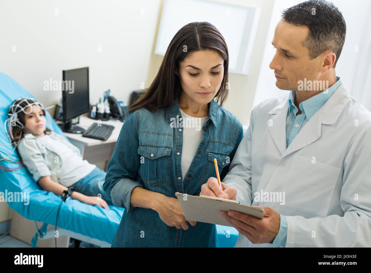Mother telling doctor about her daughters medical condition Stock Photo ...