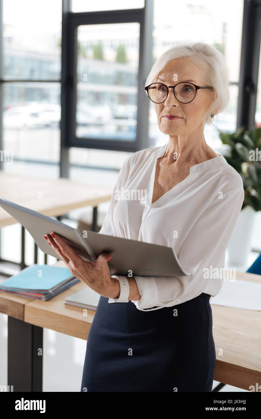 Nice pleasant woman holding a folder Stock Photo - Alamy